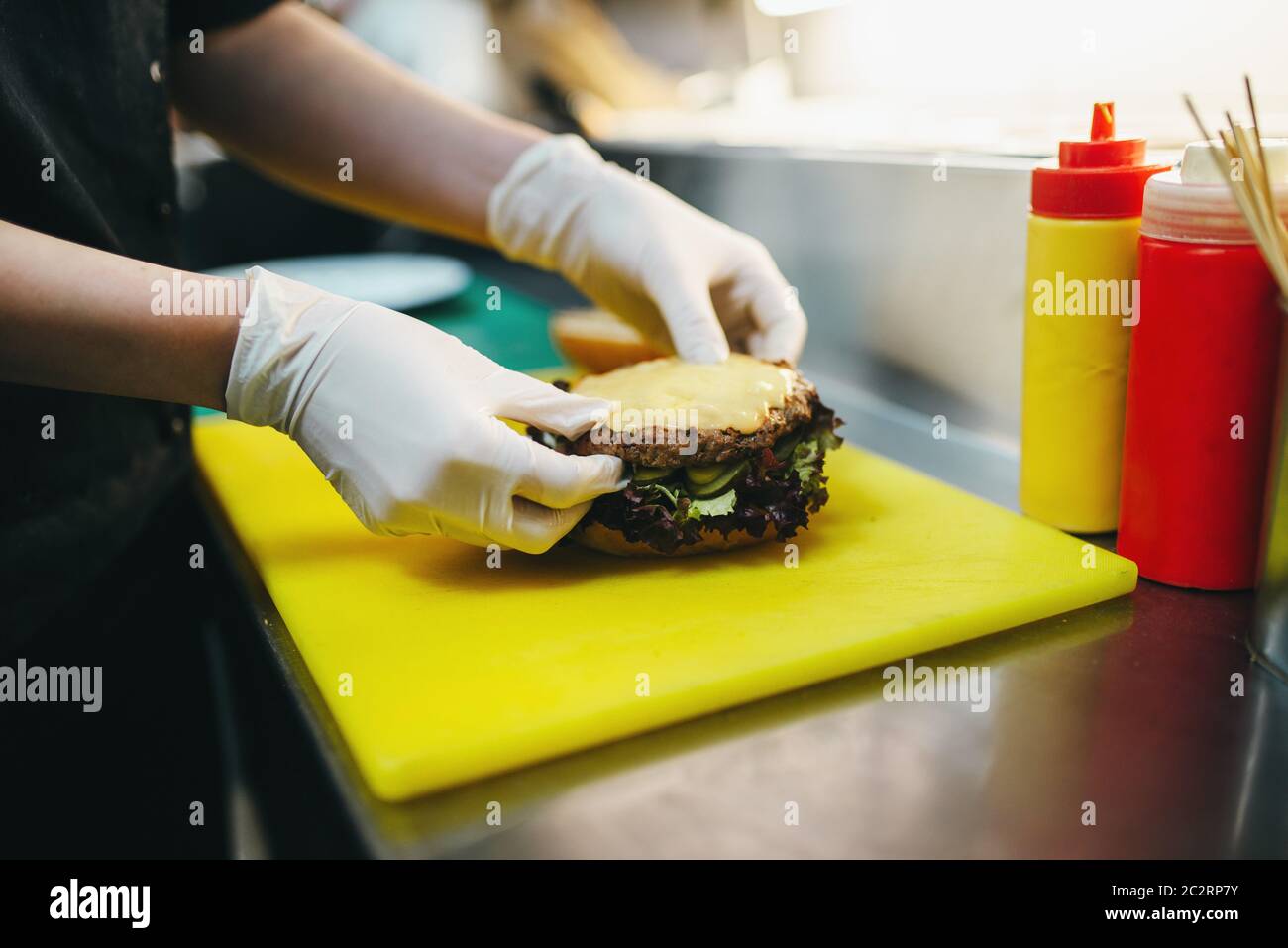 Male cook prepares fast food, burger preparation process. Fastfood ...