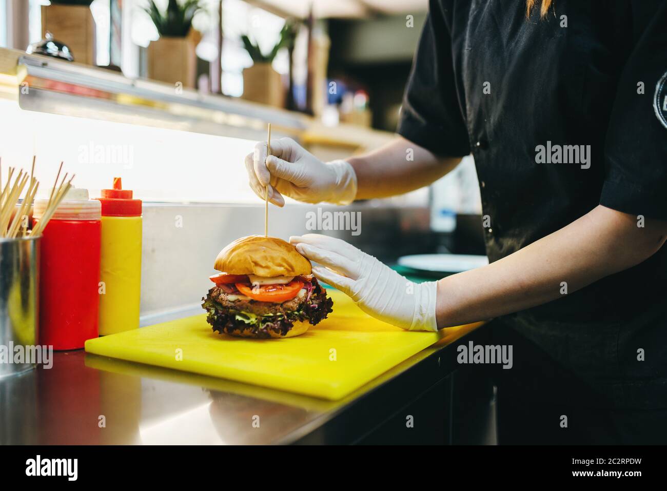 Chef prepares burger, fast food cooking. Hamburger preparation process ...
