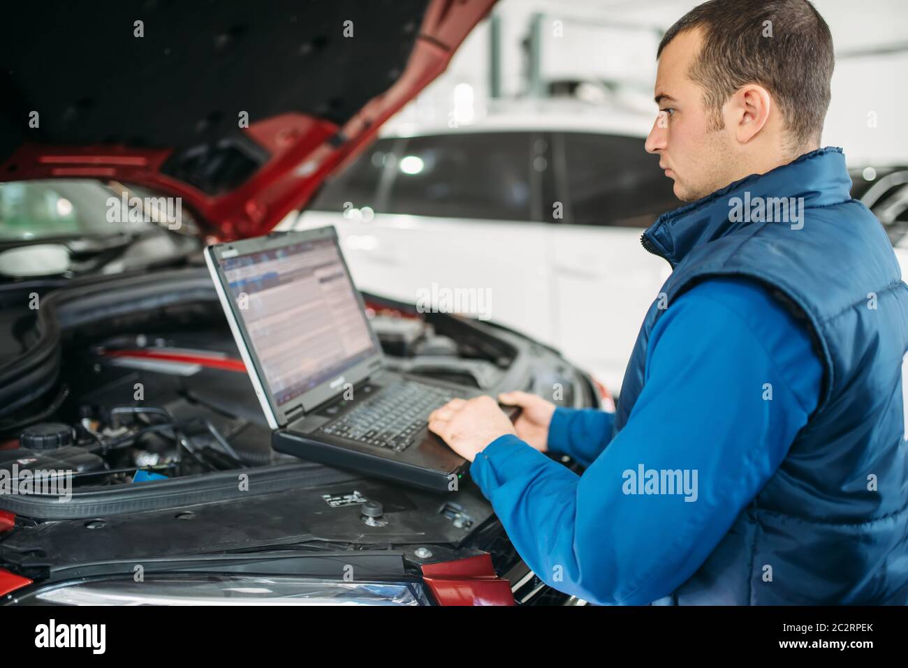 Engineer makes computer diagnostics of the car in auto-service. Vehicle ...