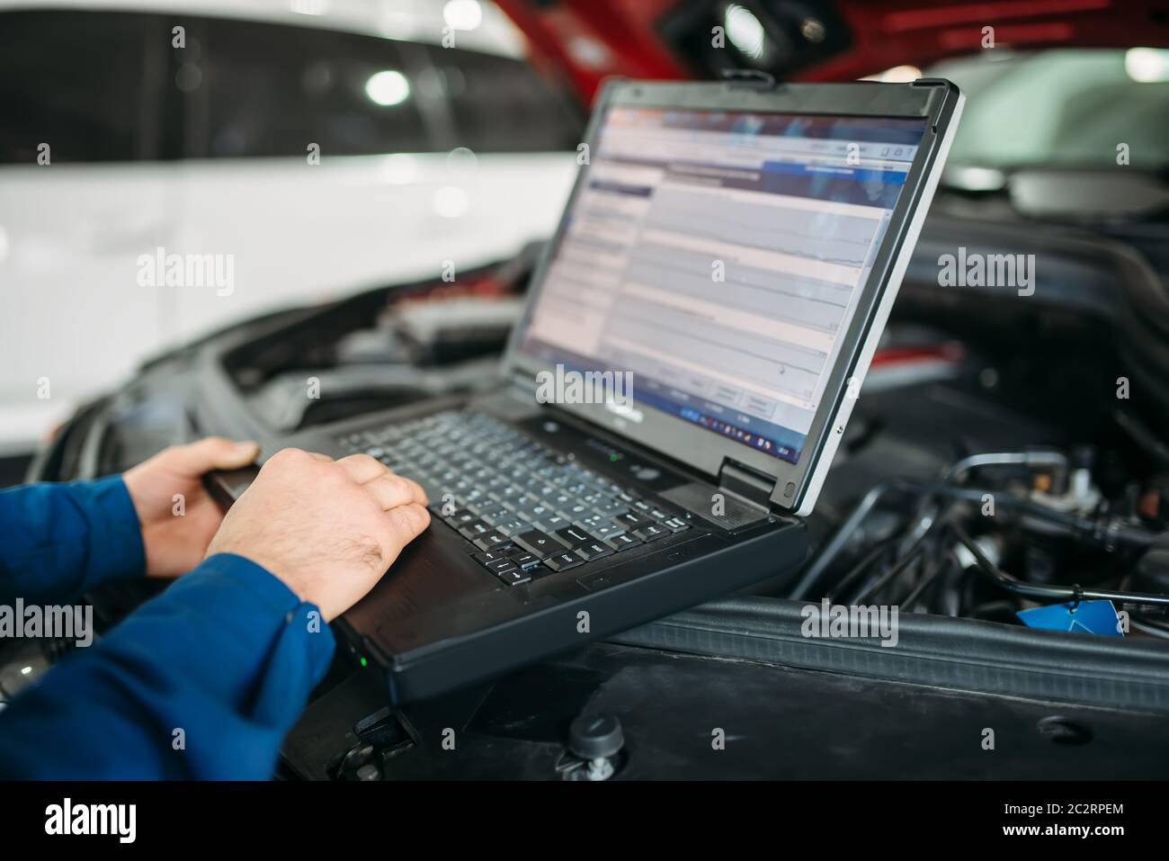 Engineer makes computer diagnostics of the car in autoservice. Vehicle ...
