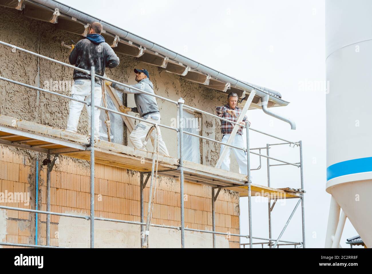 Plasterer standing on scaffolding at construction site looking into ...