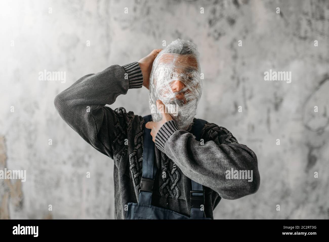 Depressed autistic wraps his head in packaging film, autism syndrome ...