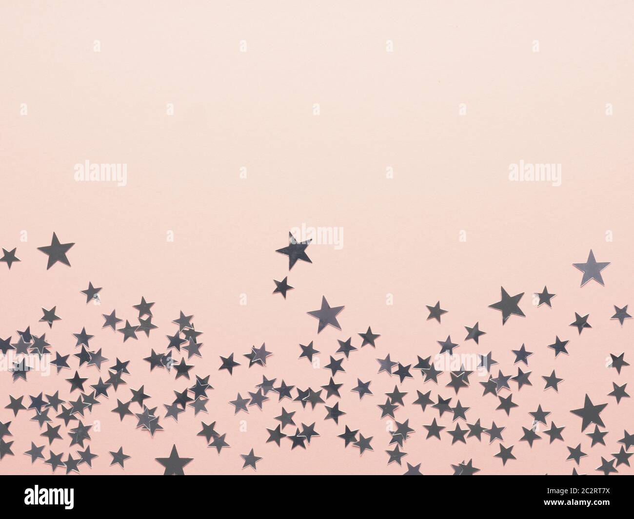 Silver plastic stars on a bright pink paper background with space for ...