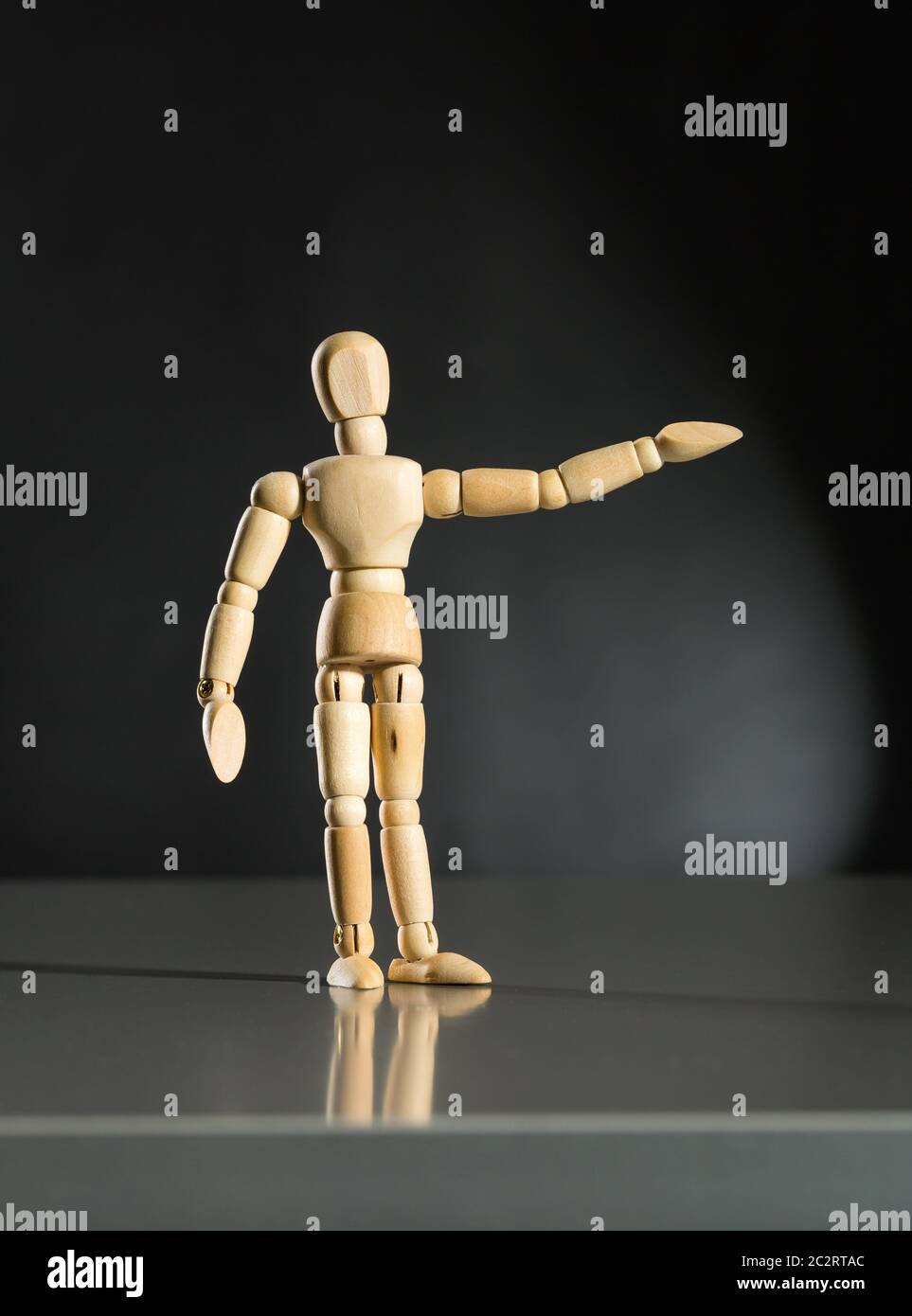 Human wood manikin pointing at something against dark background Stock ...