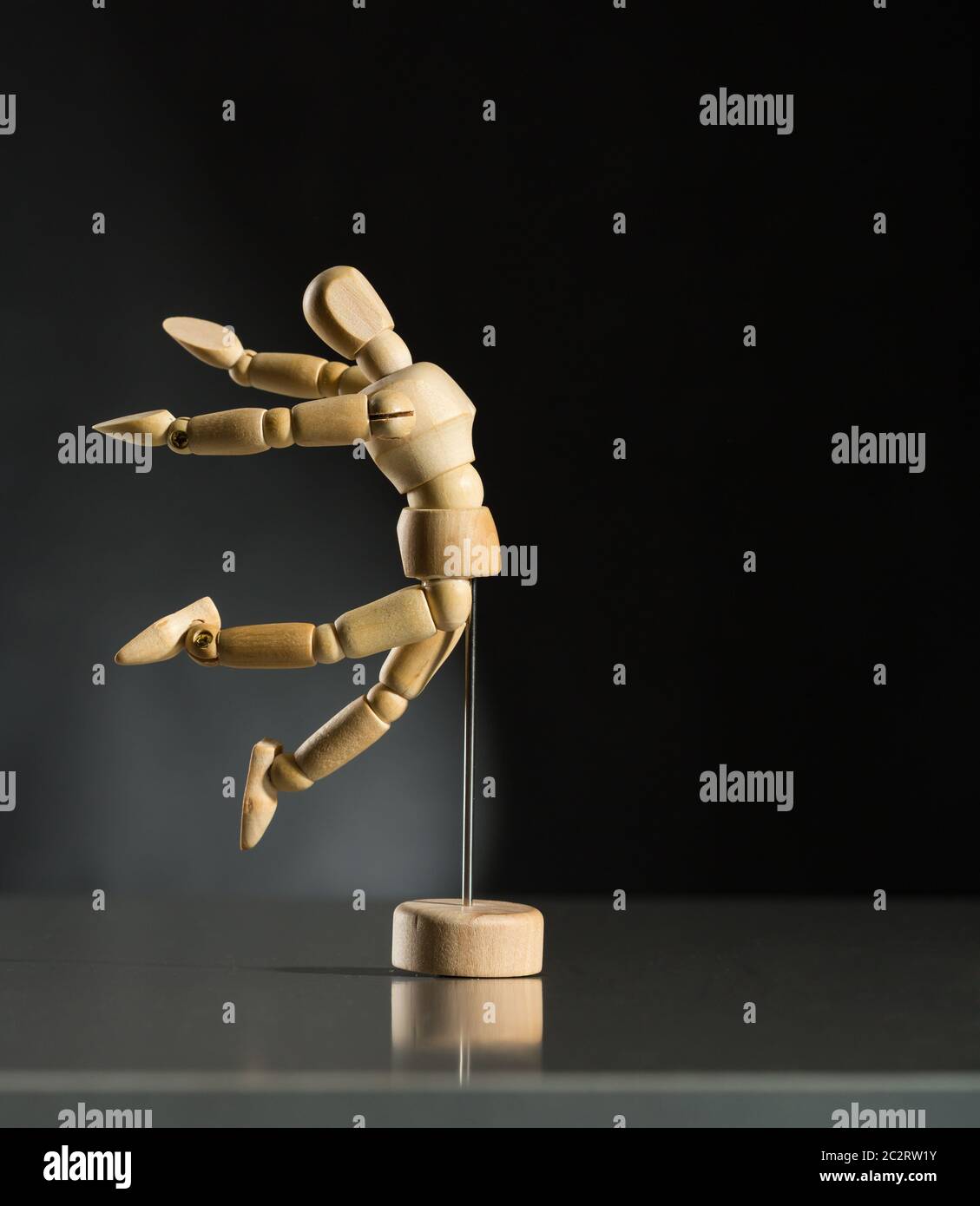Human wood manikin is jumping against dark background Stock Photo - Alamy