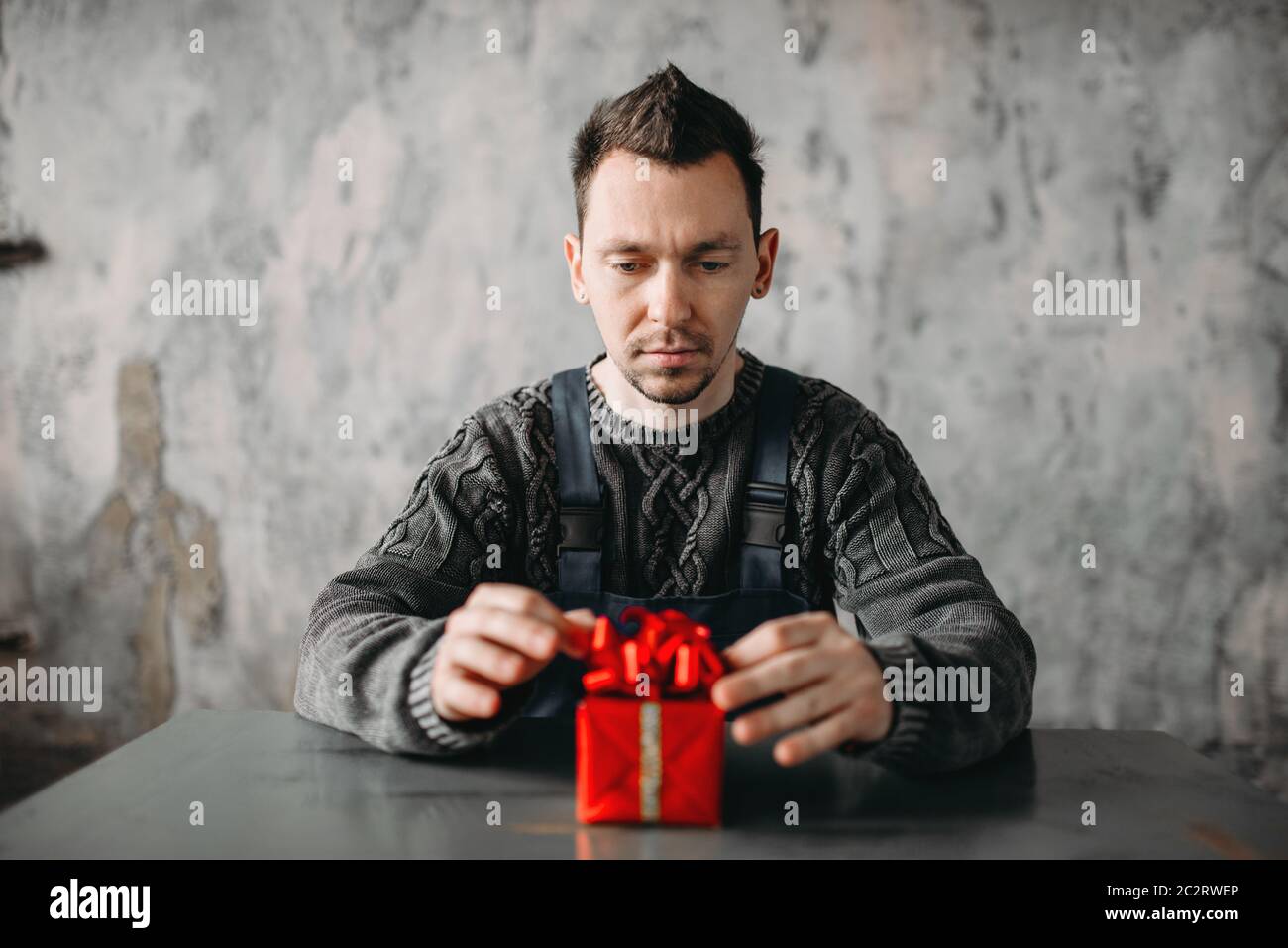 Autistic man sitting against gift in wrapping paper. Alone guy in ...
