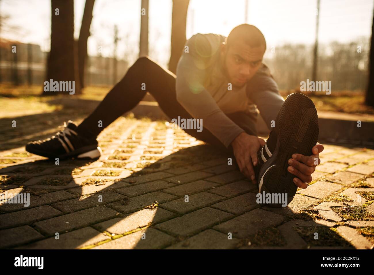 Male sportsman warming up before run. Jogger on morning fitness workout ...