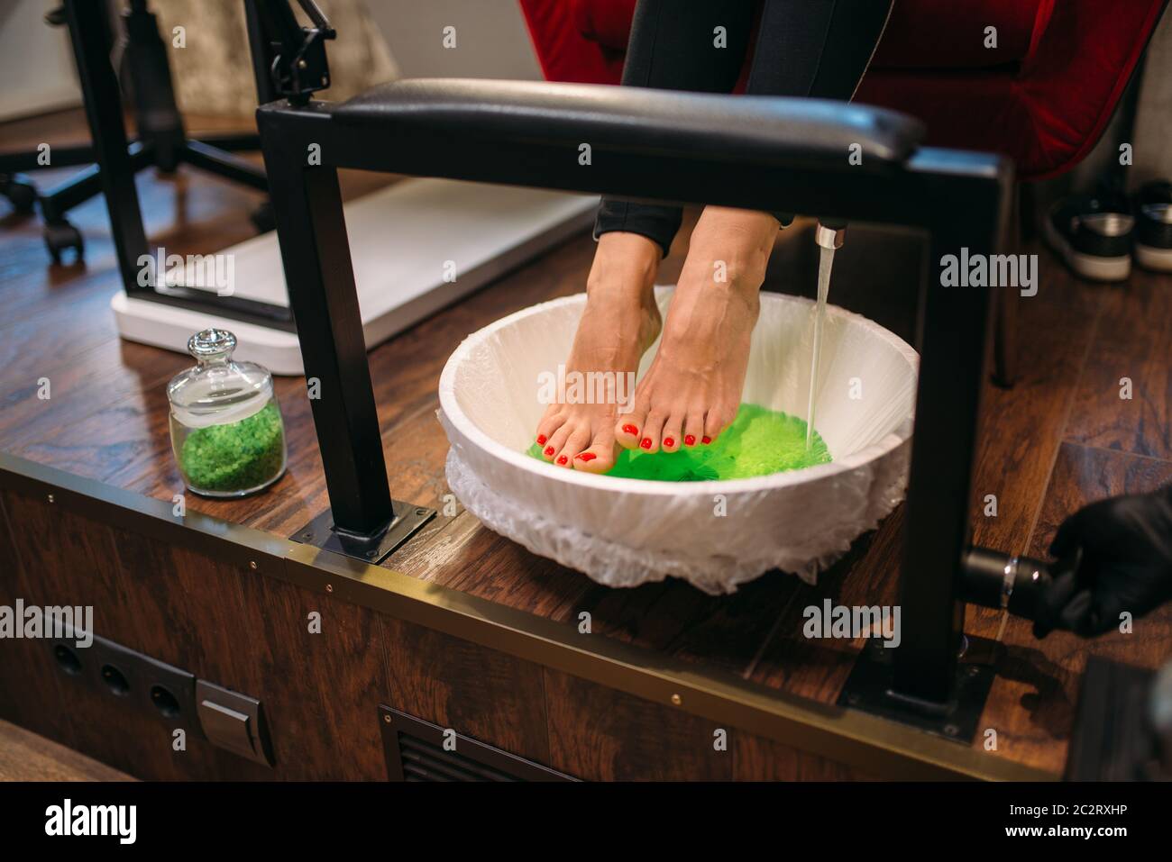 Female client feet in a pedicure bath, top view, cosmetic procedure in ...