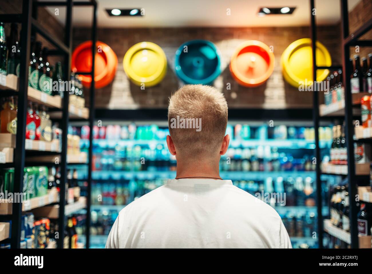 Male customer choosing drinks in supermarket. Shopping in food store ...
