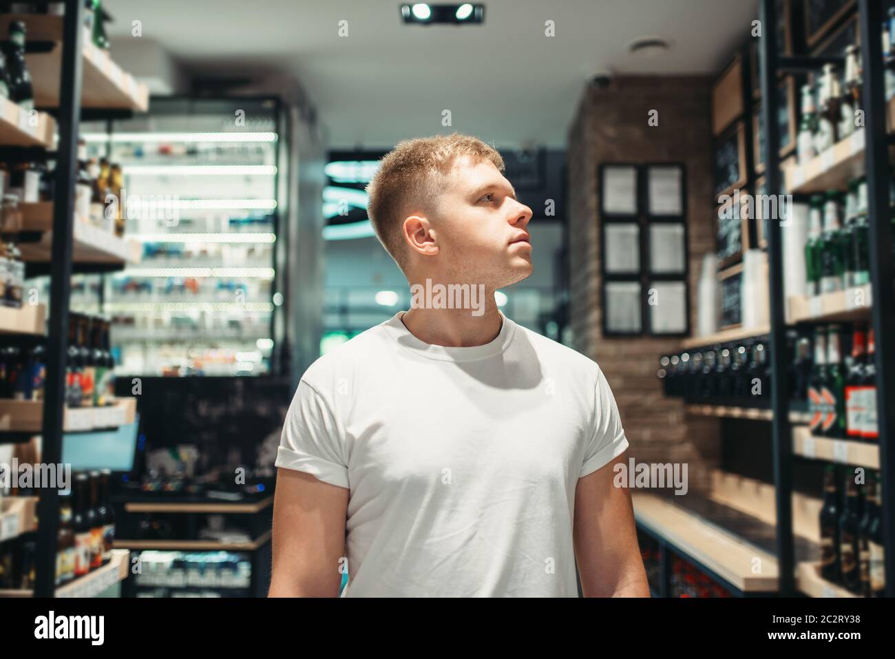 Male customer choosing drinks in supermarket. Shopping in food store ...