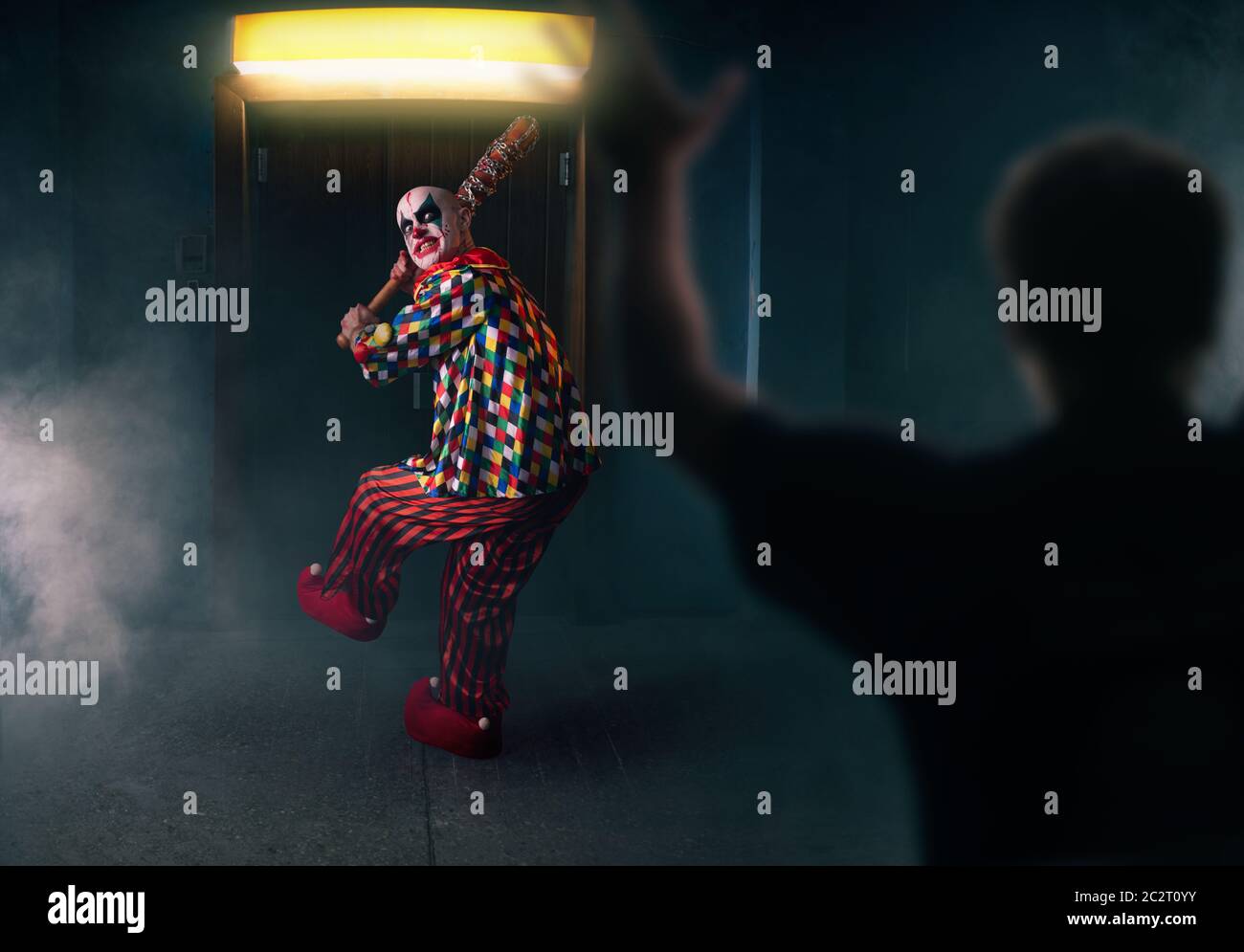 Mad bloody clown with baseball bat against his victim, horror. Man with ...