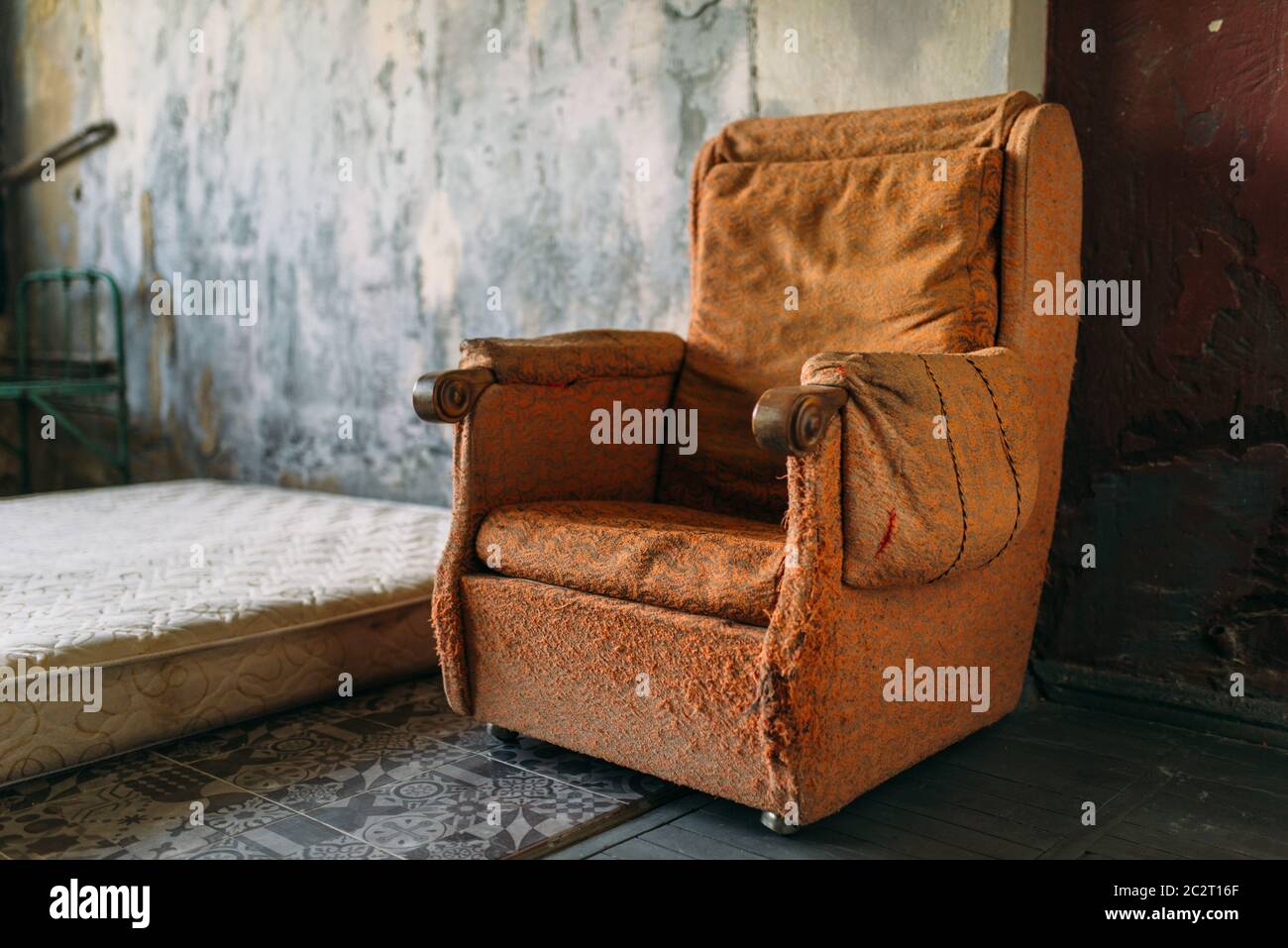 Drug addict room, grunge armchair and mattress on the floor in ...