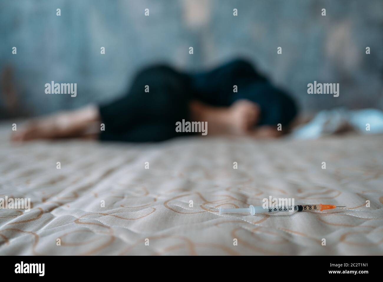 Female junkie with syringe in hand sleeping in bed after dose. Drug ...