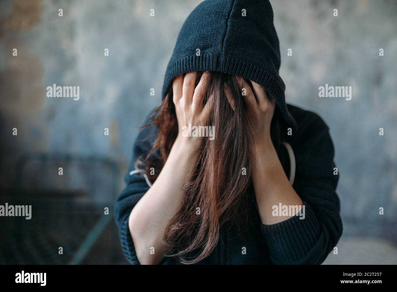 Female in a hoodie holds her head. Drug addiction concept, addicted ...