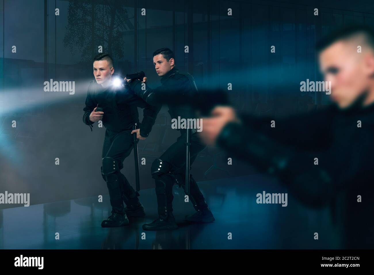 Cops with guns dressed in black uniform and body armor. Police officers ...