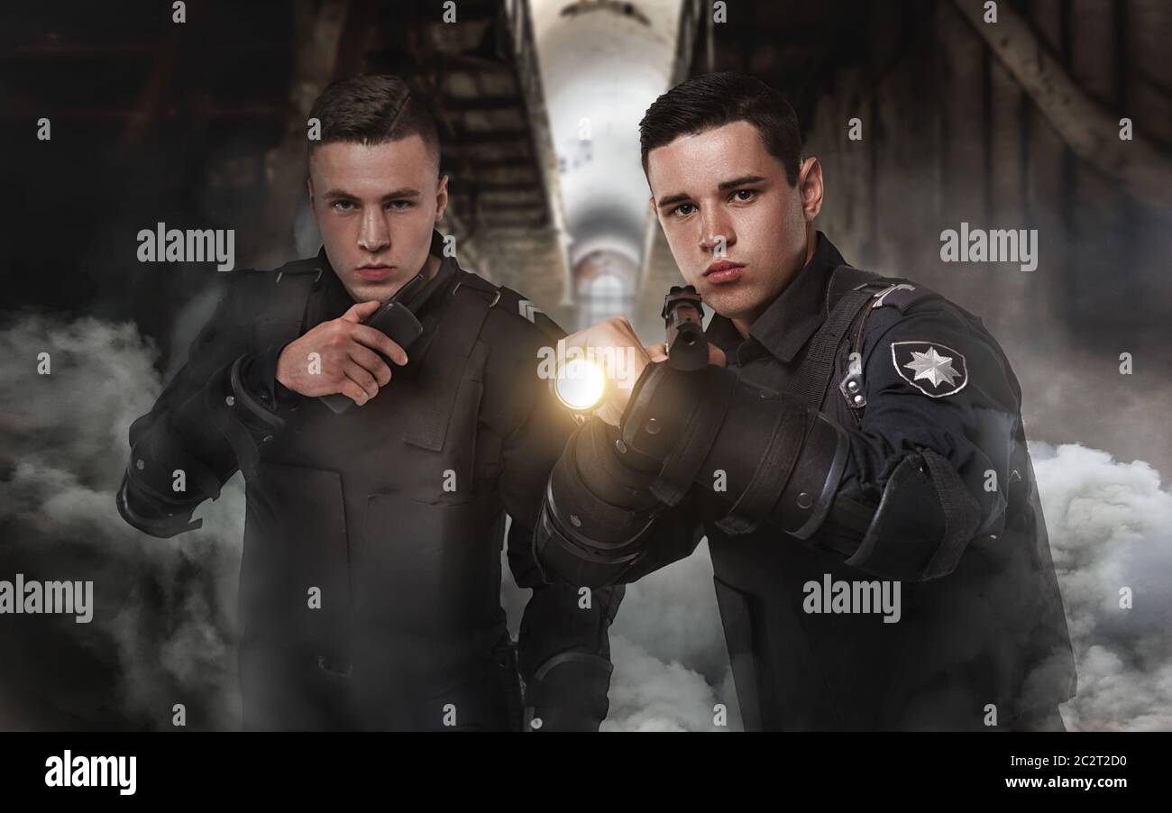Cops with guns dressed in black uniform and body armor. Police officers ...