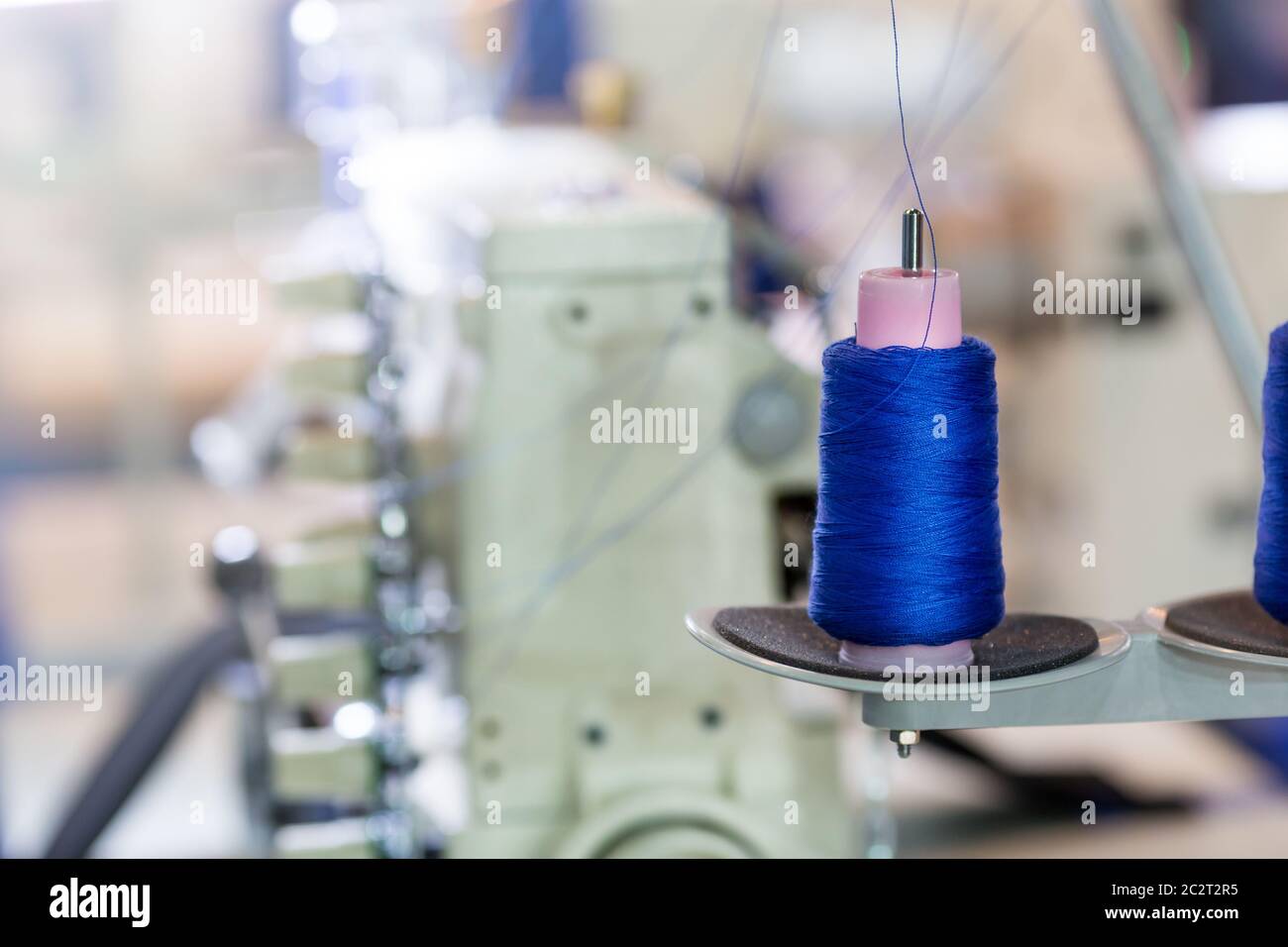 Spools of blue threads on sewing machine closeup. Cloth factory ...