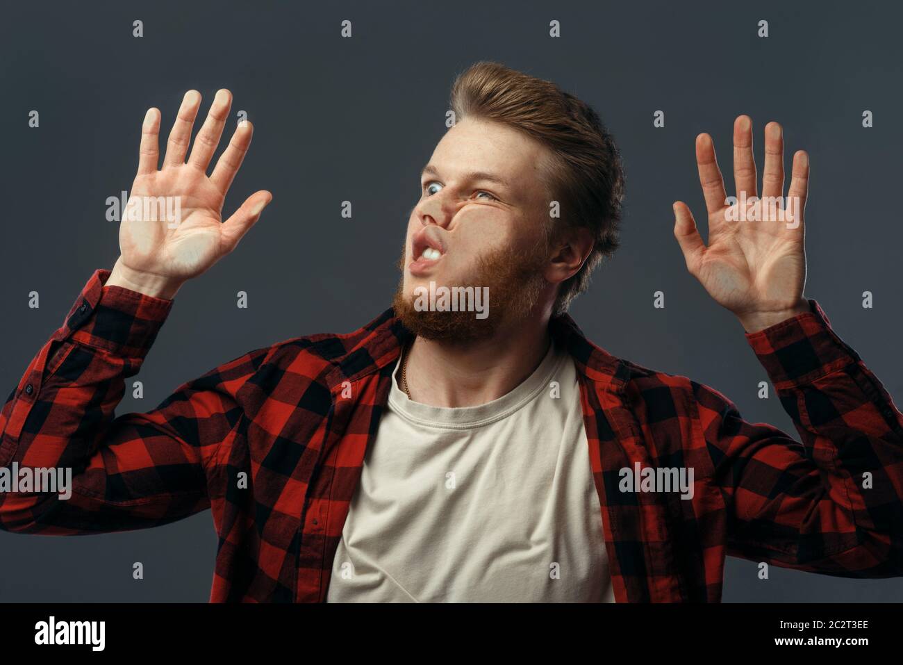 Young man's funny face crushed on transparent glass. Male person with ...