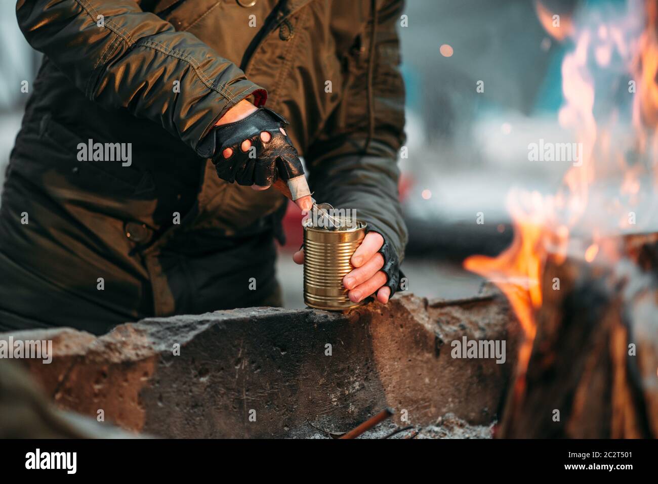 Stalker, male person cooking canned food on fire. Post apocalyptic ...