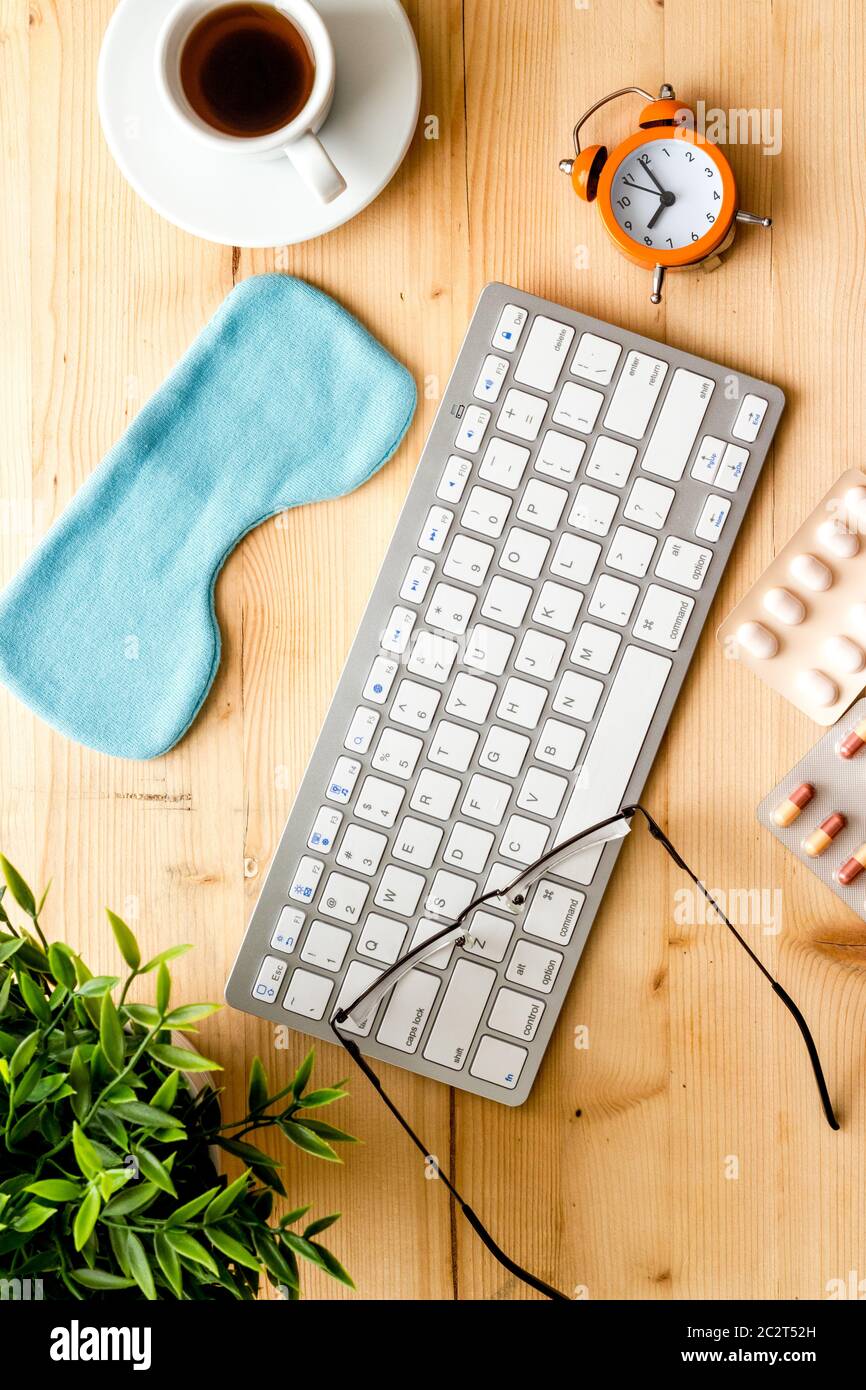 insomnia at work. Sleep mask on wooden office desk top view Stock Photo ...