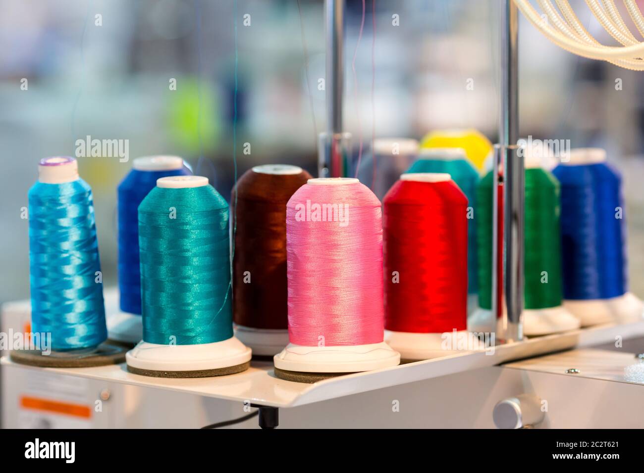 Spools of color threads closeup, sewing material. Cloth factory ...