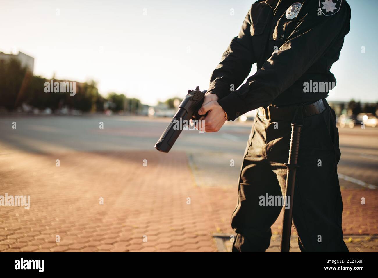 Male cop in uniform with gun in hands. Police officer with weapon. Law ...