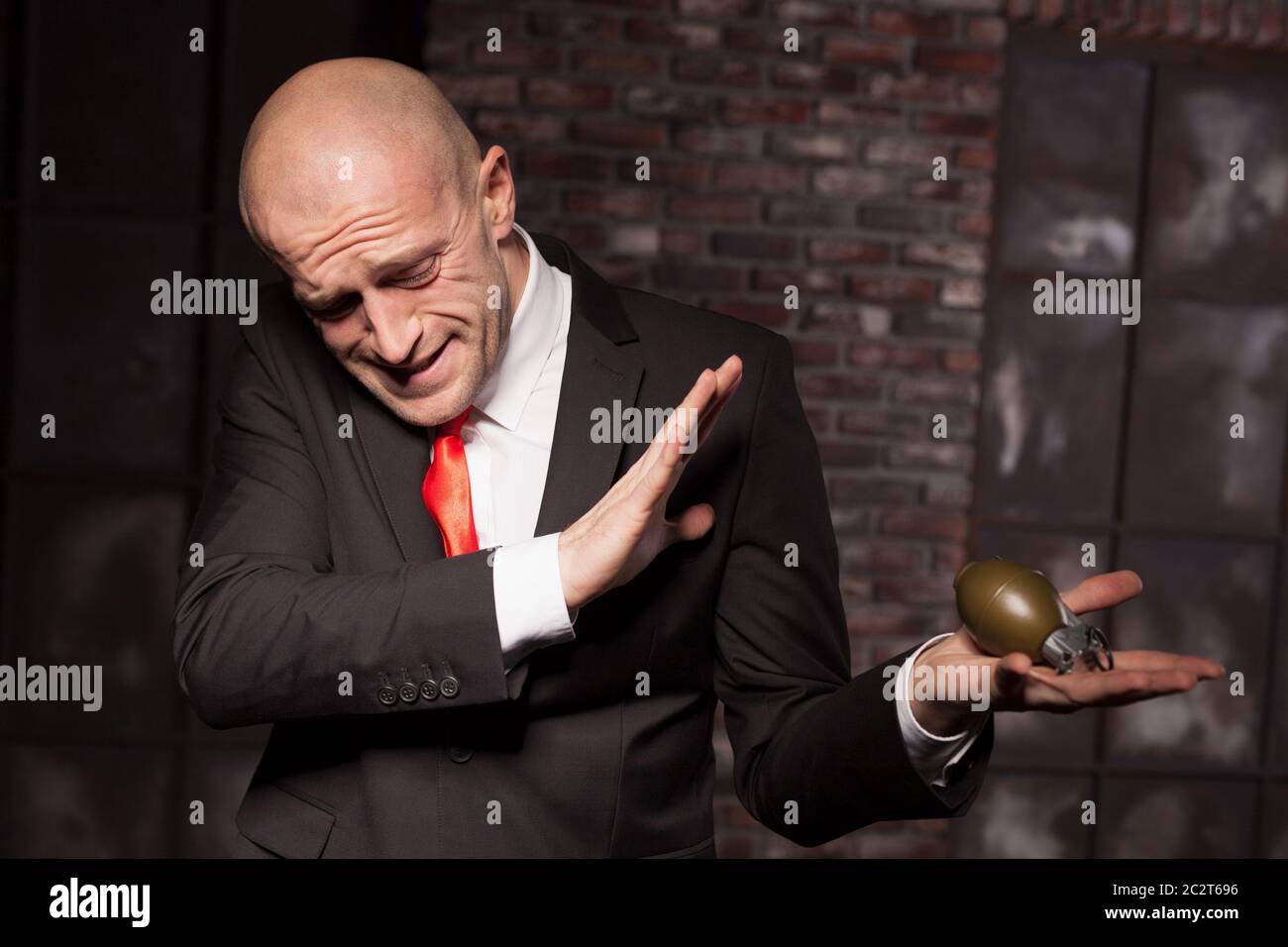Contract murderer in suit and red tie afraid of armed grenade explosion ...