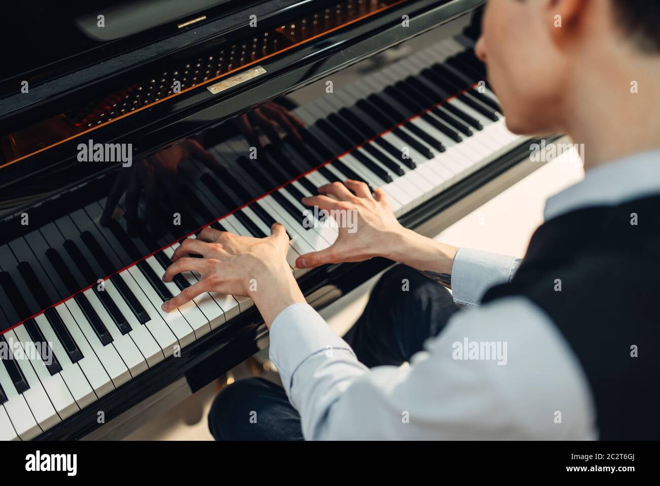 Pianist playing music on grand piano, back view. Musician practicing ...