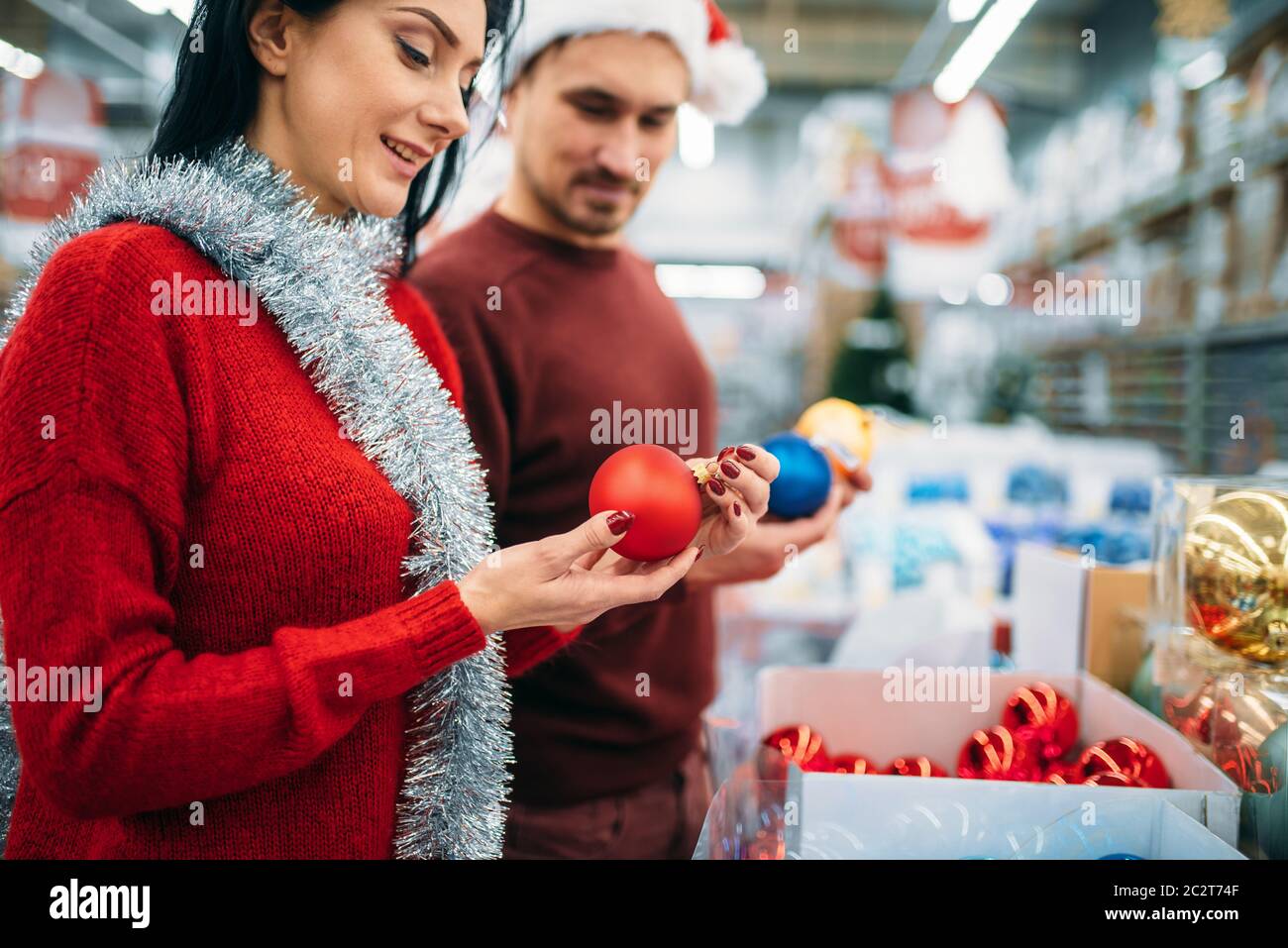 Happy couple chooses christmas tree balls in supermarket, family ...