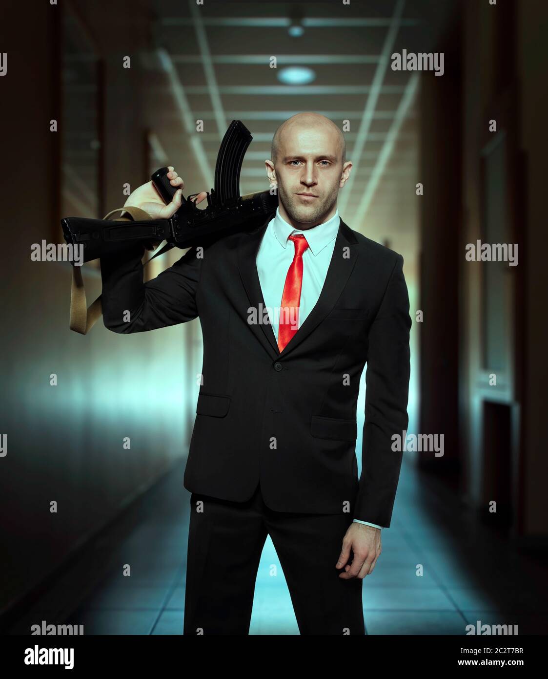 Hired murderer in suit and red tie holding machine gun in hands ...