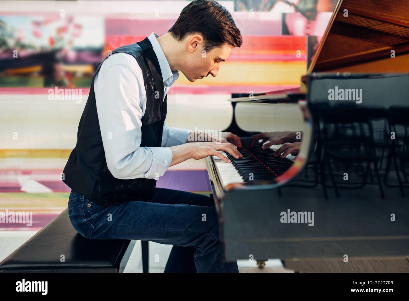 Male pianist practicing composition on grand piano. Musician plays ...