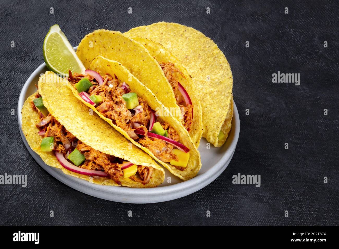 Cochinita pibil taco shells, a Mexican snack with pulled pork, avocado ...