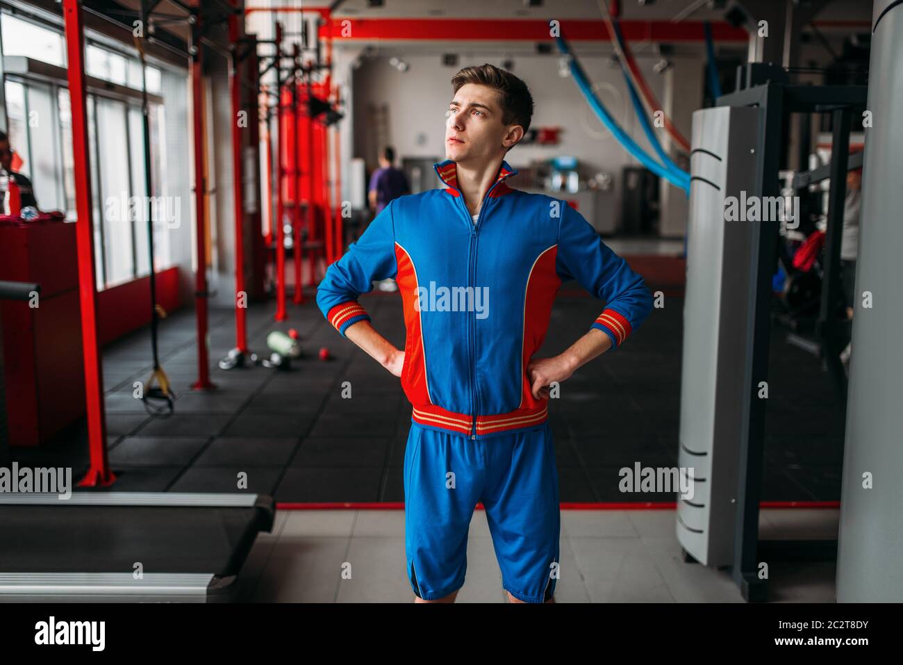 Skinny man in sportswear at the gym, humor. Weak male person in sport ...