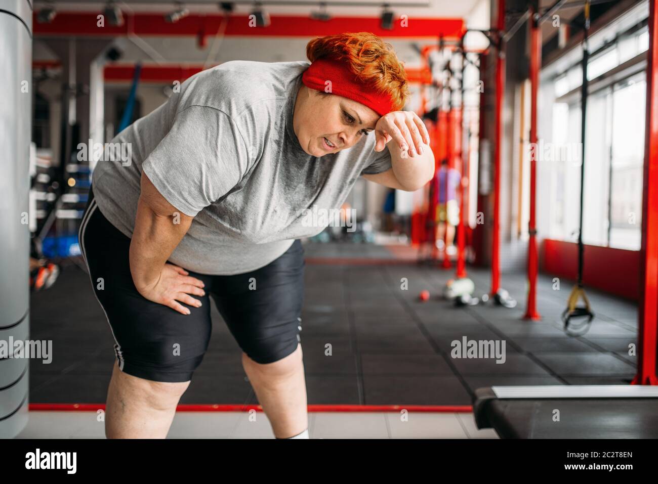 Tired fat woman after active training in gym. Calories burning, obese ...