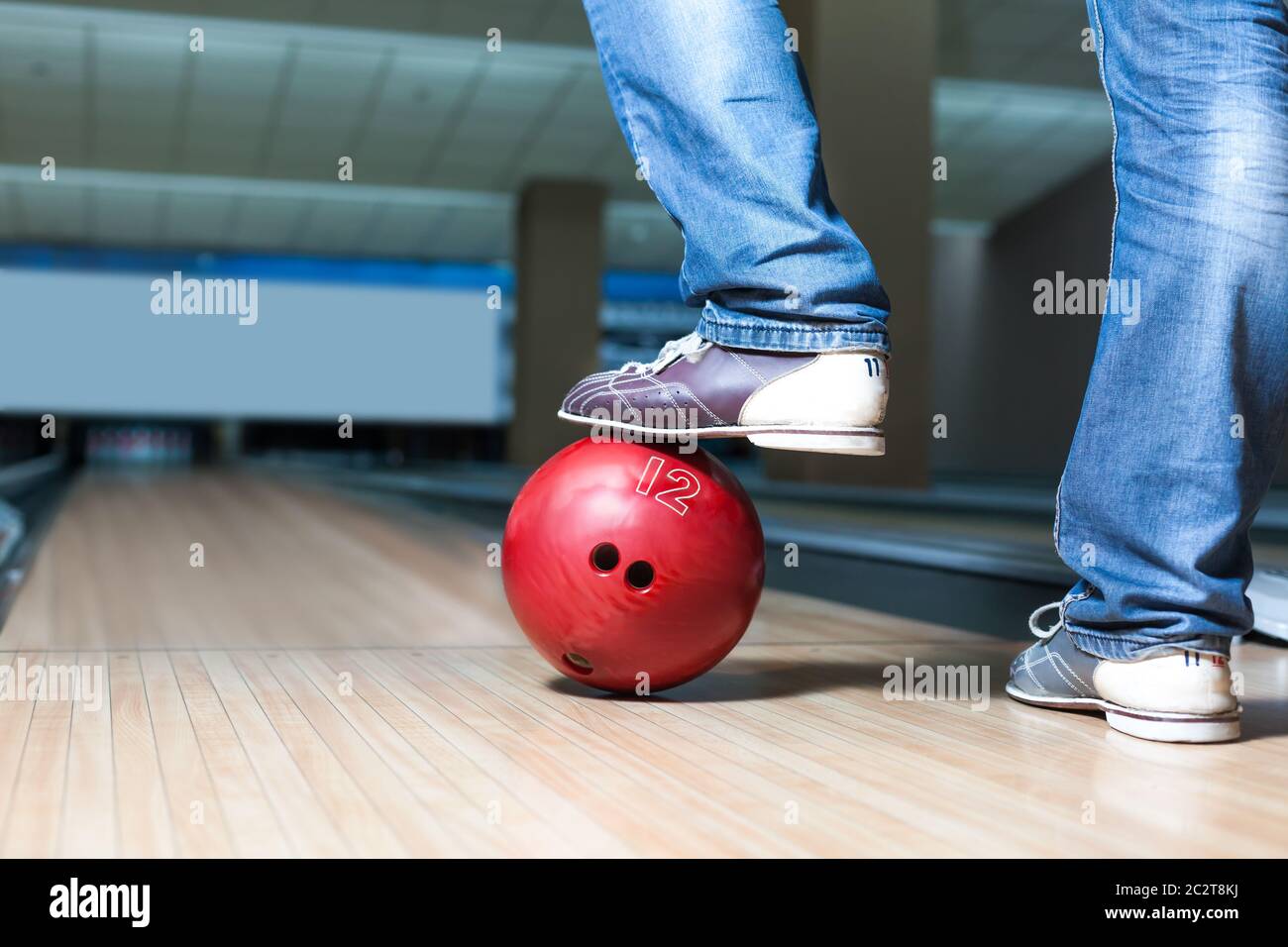 Man playing football with bowling ball Stock Photo - Alamy