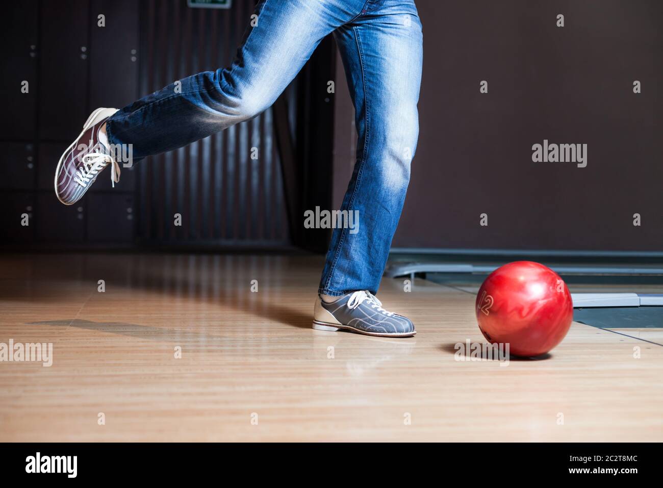 Man playing football with bowling ball Stock Photo - Alamy