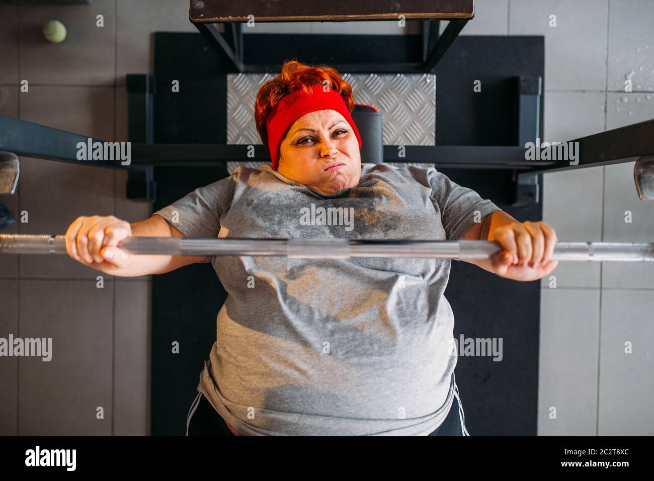 Fat sweaty woman, workout with barbell in gym, top view. Calories ...
