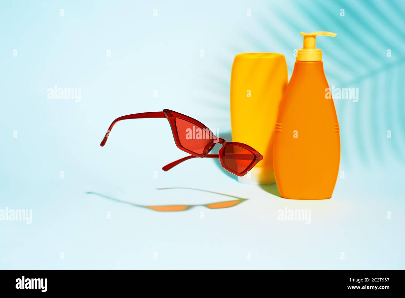 Two orange containers without label for lotion, flying sunglasses on ...