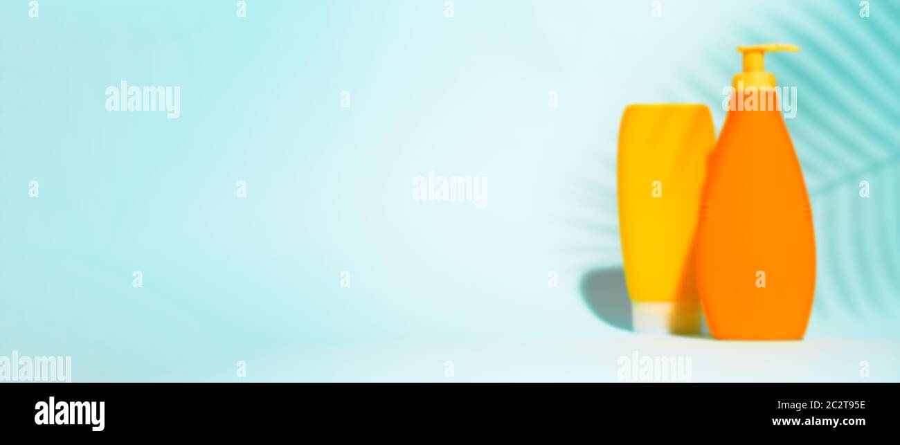 Two orange containers for lotion without label on blue background with ...