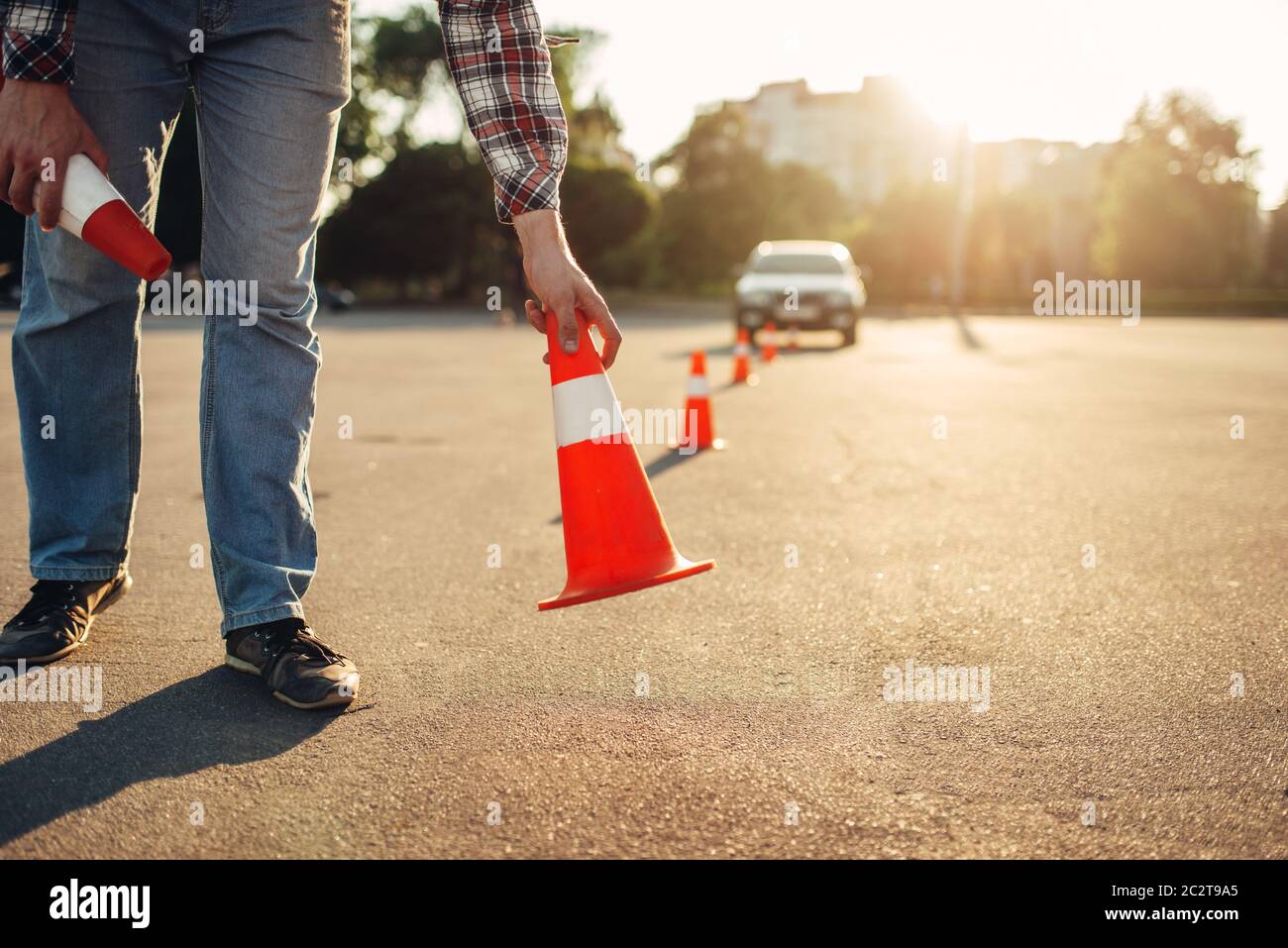 Instructor sets the cone for the examination, driving school concept ...