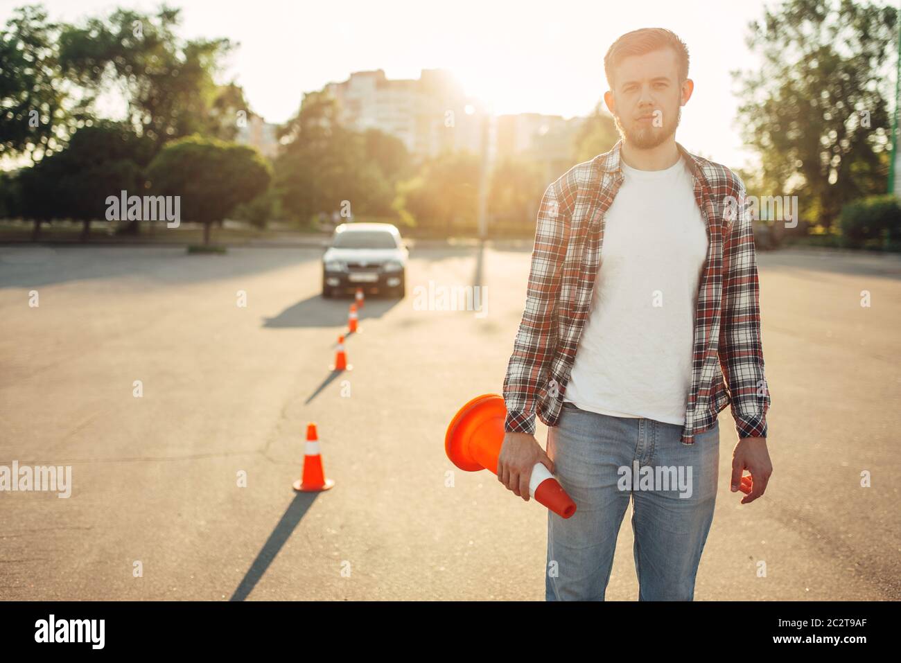 Instructor sets the cone for the examination, driving school concept ...