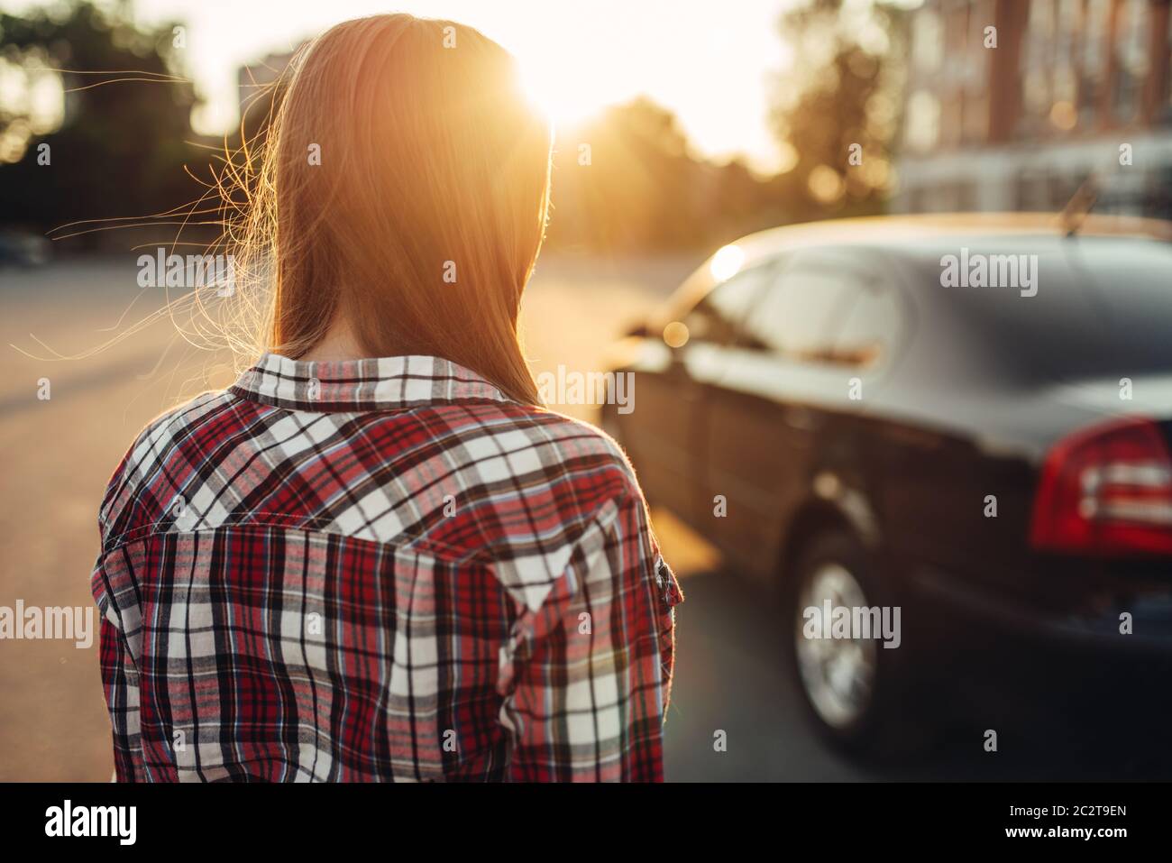 Young cheerful woman driver posing against a car. Female person and ...