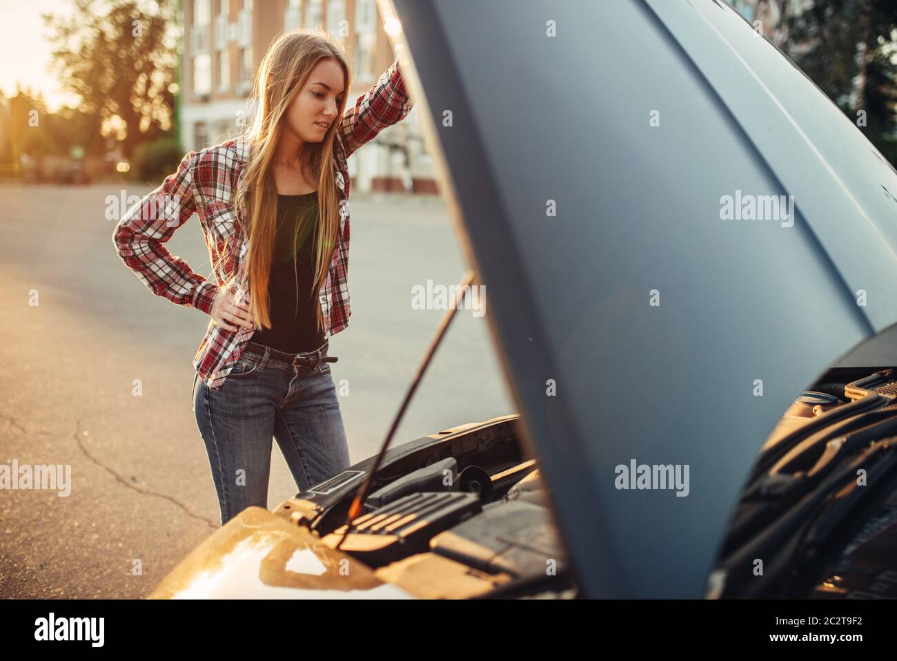 Car breakdown concept, woman standing against open hood on the roadside ...