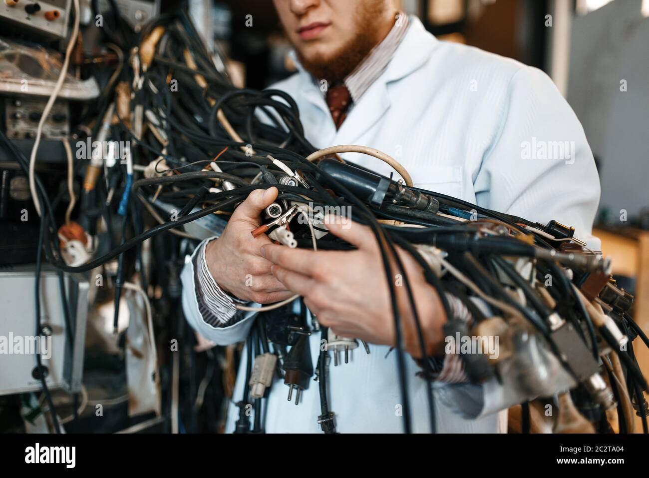 Strange engineer holds bunch of wires with different plugs in ...
