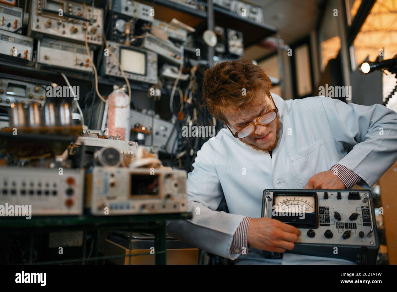 Crazy scientist holds electrical device in laboratory. Electrical ...