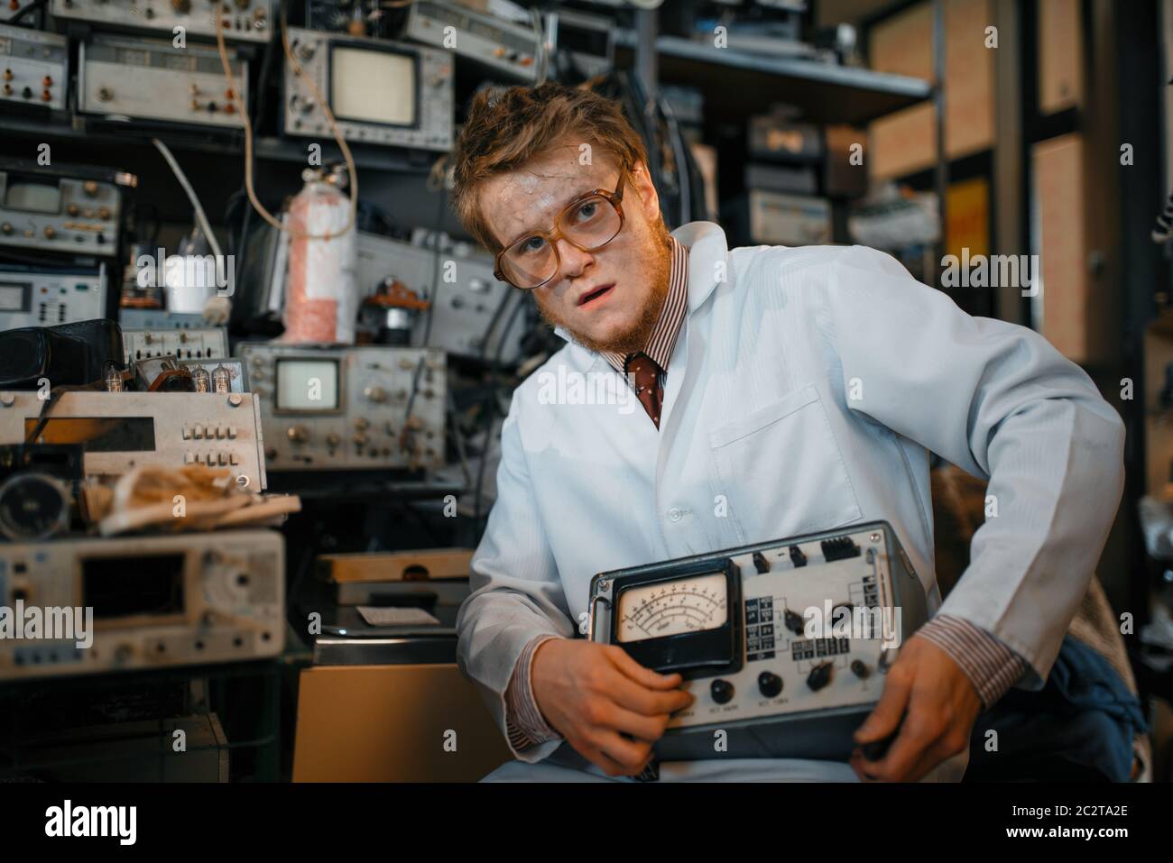Crazy scientist holds electrical device in laboratory. Electrical ...