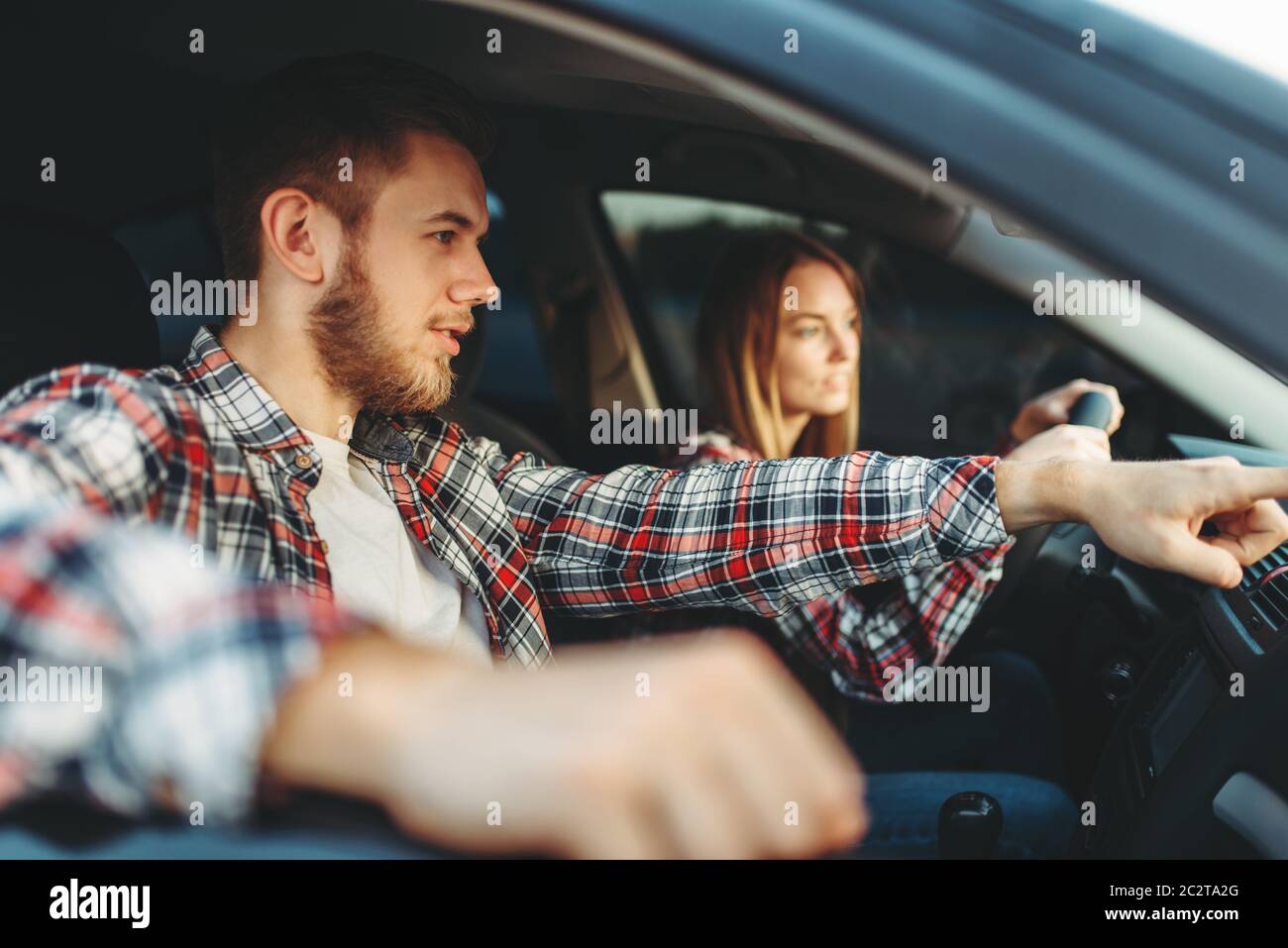 Male instructor and woman student, driving lesson, car school concept ...