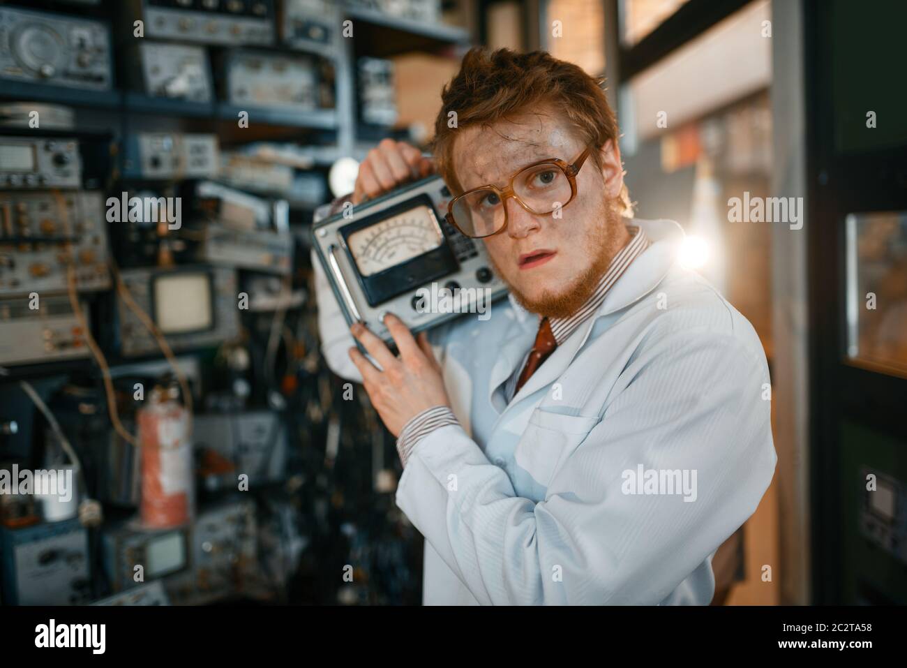 Crazy scientist in glasses holds electrical device in laboratory ...