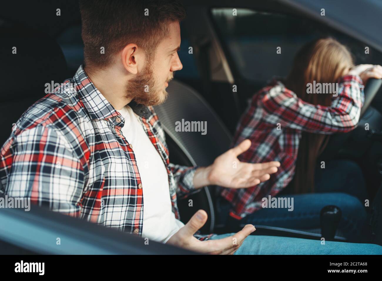 Male driving instructor and sad female student in vehicle, bad exam ...