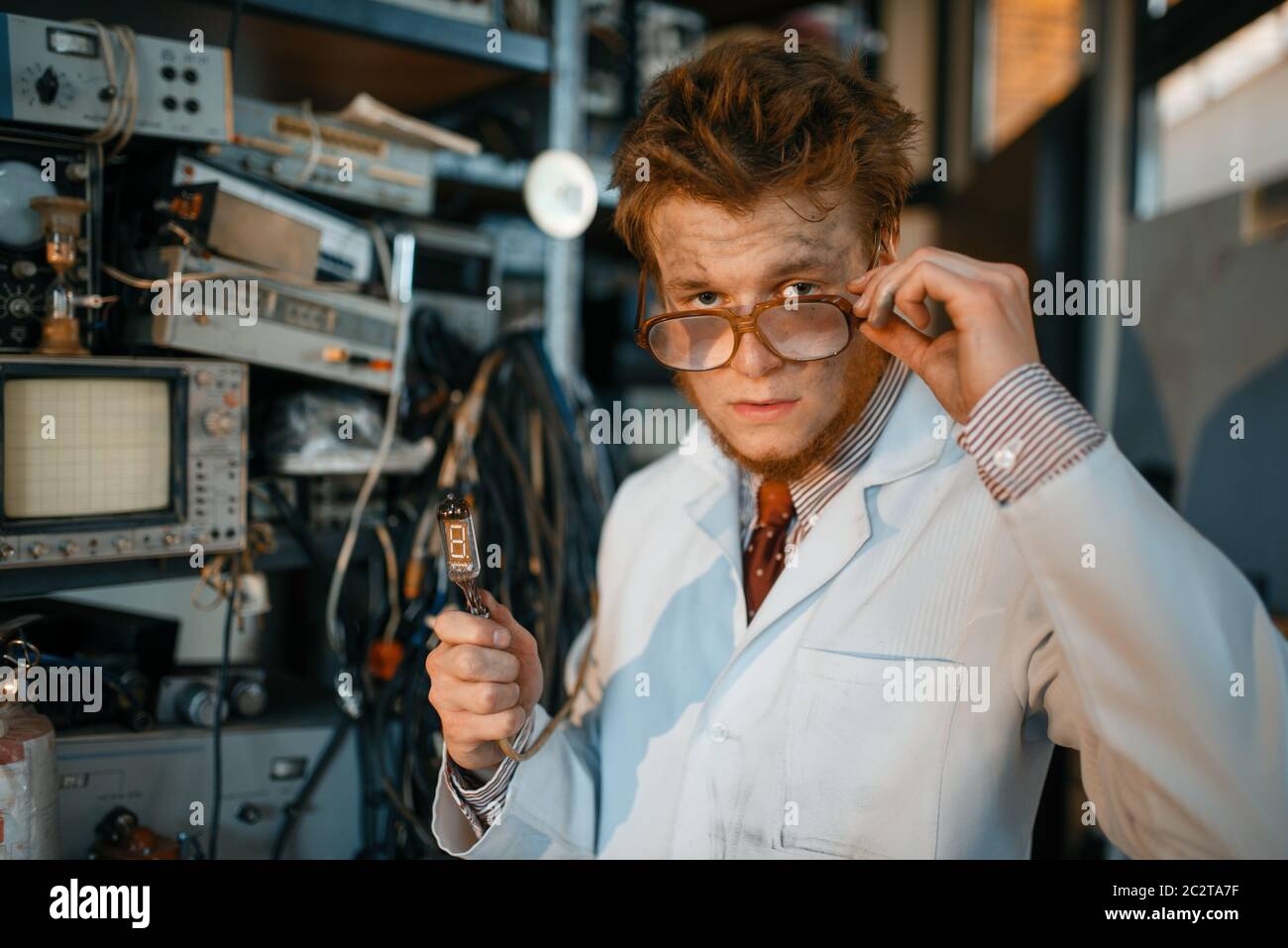 Strange engineer holds electric tube in laboratory. Electrical testing ...